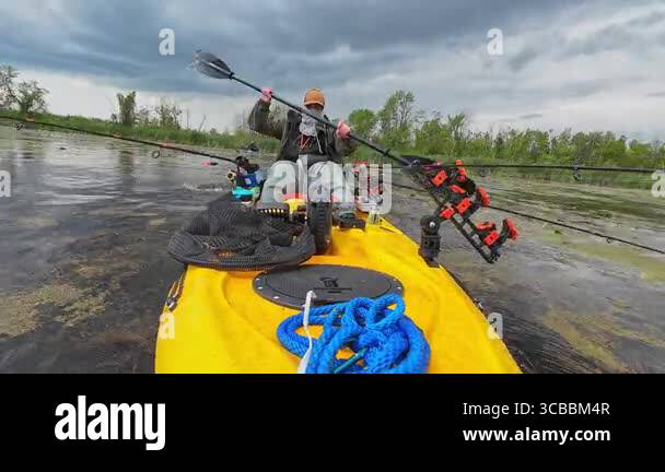 Kayak fishing, angler paddling in fishing pdl kayak during storm wind ...