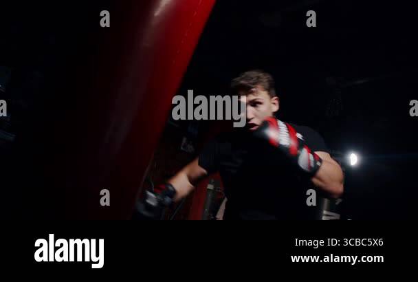 In a dim boxing ring, a determined man displays his skills in an ...