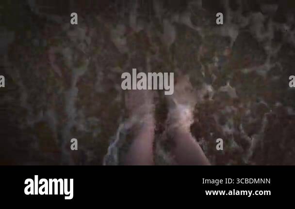 Sea wave washes womens legs. Woman stands on the ocean shore. female ...