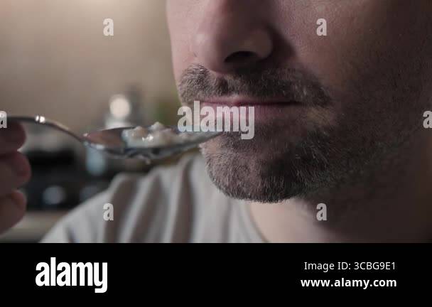 Closeup shots of a man enjoying food with a spoon, capturing his ...