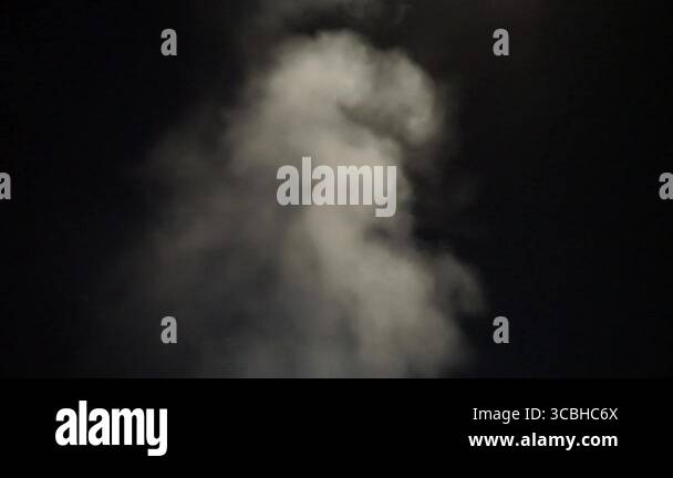 Plumes of smoke flying up against the background of the black night sky ...