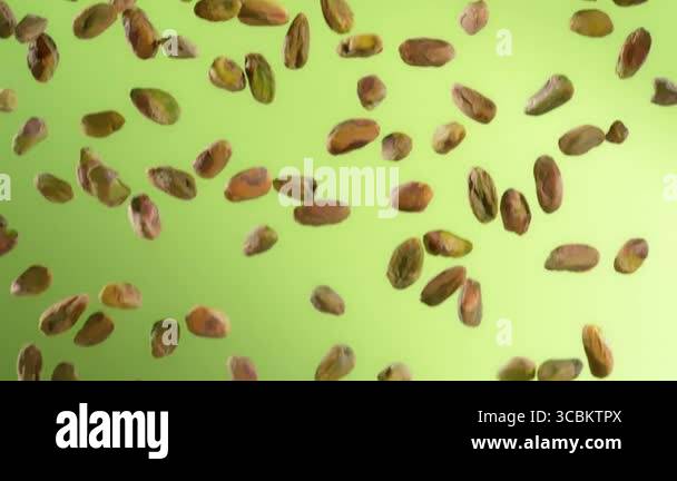 Super Slow Motion Shot of Falling Peeled Pistachio Nuts on Green ...