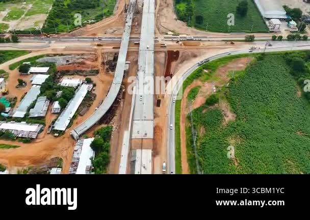 Drone shot of highway and overpass construction site with vehicles and ...