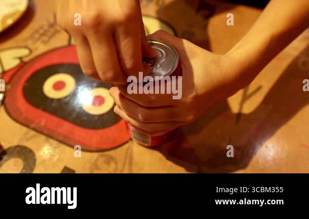 Hand opening a cola can on table Stock Video Footage - Alamy