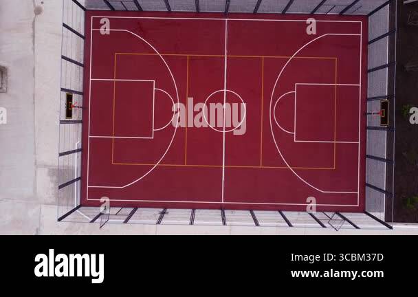 Aerial perspective of a red basketball court featuring white lines and ...
