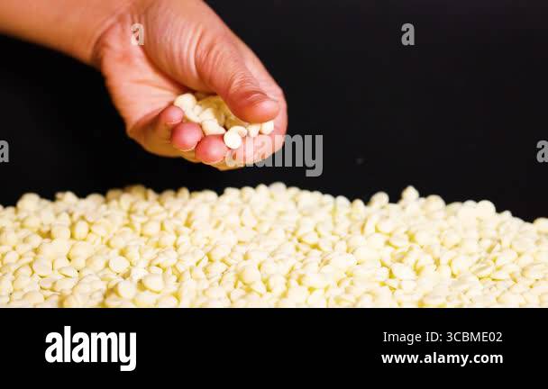 Hand scooping white chocolate chips from pile Stock Video Footage - Alamy