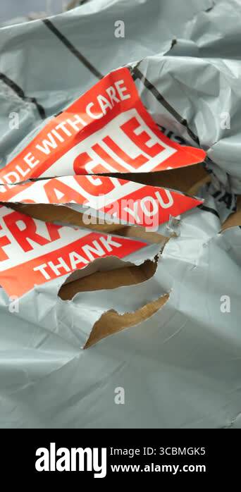 A damaged package is left at the doorstep, showing torn wrapping Stock ...