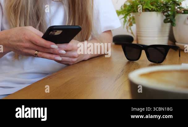Woman hands send messages in chat on smartphone at wooden table with ...