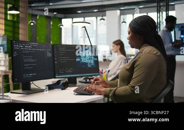 Jolly female programmer at office desk pleased after developing application using machine ...