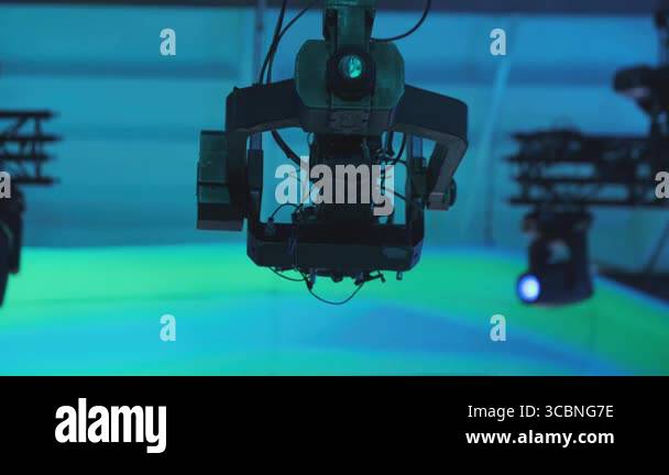 Robotic camera system in studio setting under colorful blue and green ...