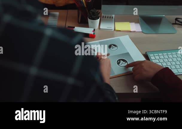 A person is actively using a computer at a desk filled with colorful ...