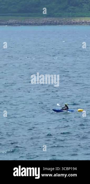 4K, View of a man rows an outrigger canoe on the still ocean water ...