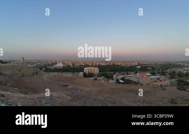 Time lapse of a cityscape at dusk, with a clear sky and scattered buildings. Aleppo, Syria Stock ...