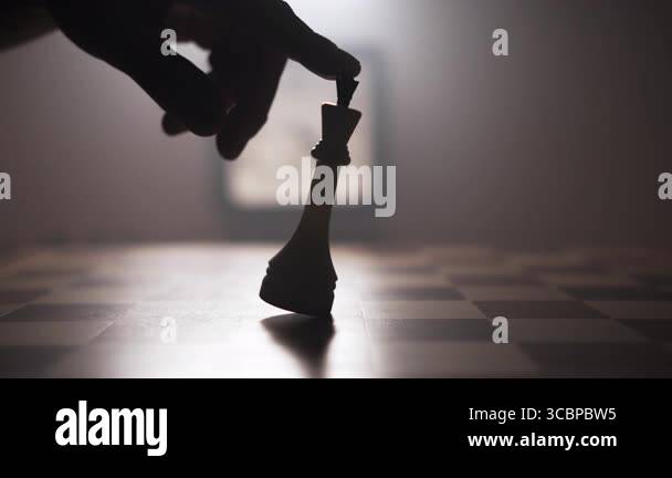 A person hand swings a chess piece on a chessboard in a circular motion ...