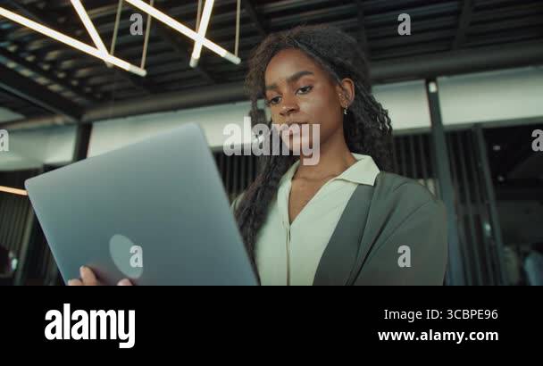A professional woman is intensely focused on her laptop while working ...