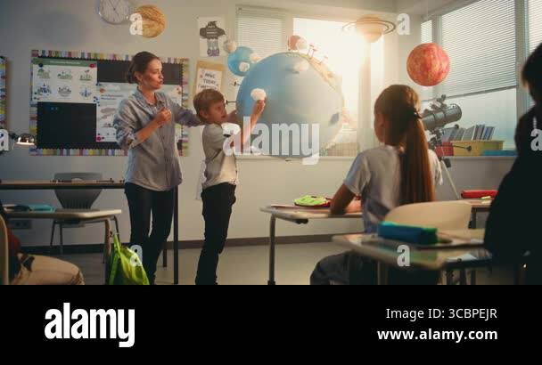 STEM Class: School Boy Presenting Renewable Energy Sources Using Model of Planet Earth. Female ...