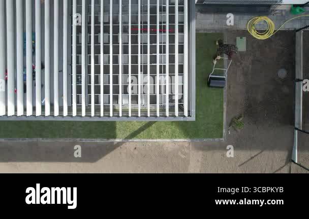 Aerial view showcases a contemporary building with a striking roof ...