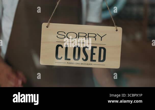 Closeup view of server hands turning sign Closed to Open on glass cafe ...