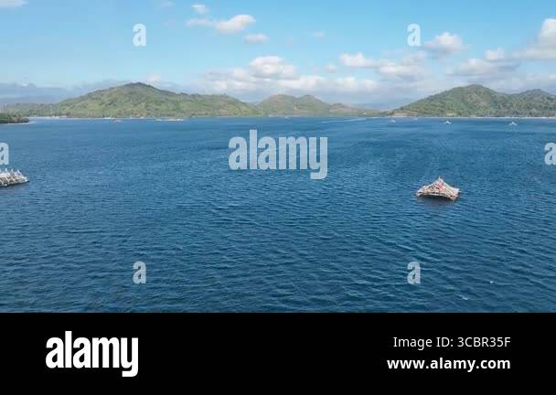 Traditional bamboo fishing platforms float on the open sea with green ...