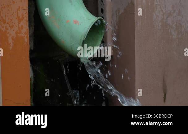 Close-Up of Water Flowing from Green Rain Gutter Pipe in Urban ...