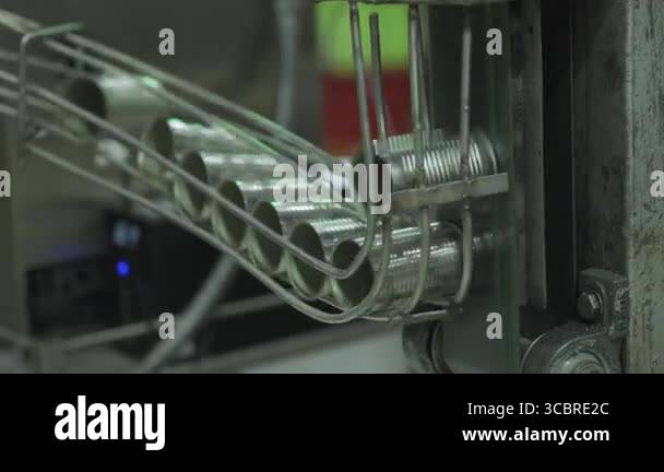 Empty aluminum cans travel through a metal guide rail in an automated ...