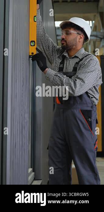Professional builder wearing protective safety gear carefully checking ...