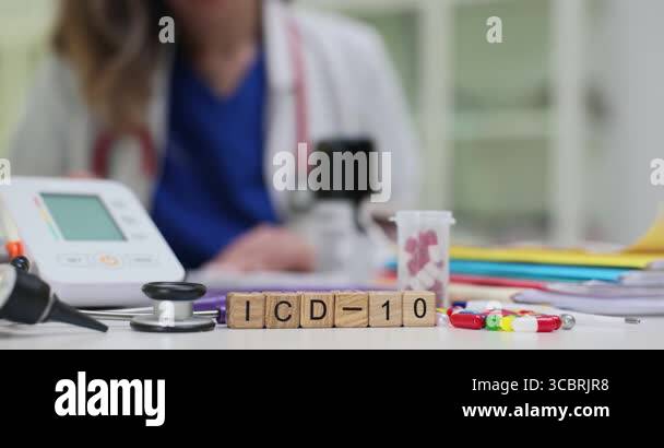 Wooden cubes form ICD-10 word on desk near blood pressure monitor ...