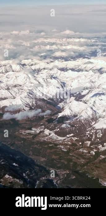 Vertical Above the peaks with clouds, capped Alps with rugged mountain ...