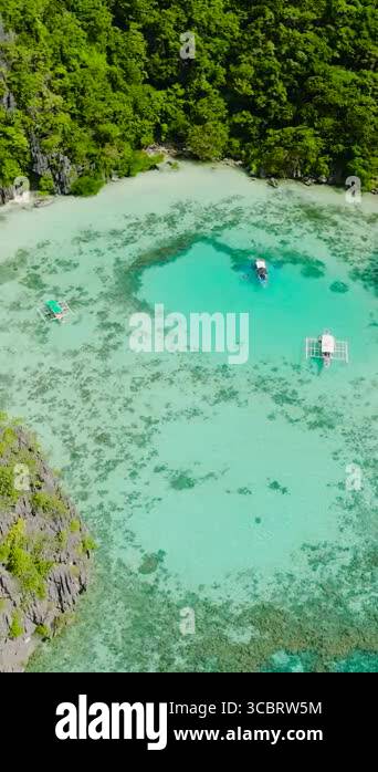 Boats on transparent turquoise water in Smith Point Beach in Coron ...