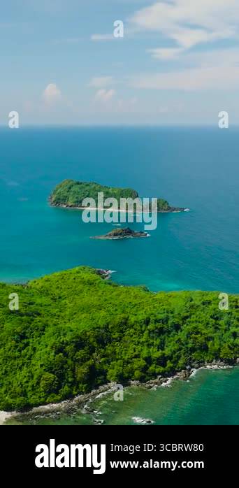 Tropical Island with rocky coastline and small islands with blue sea ...