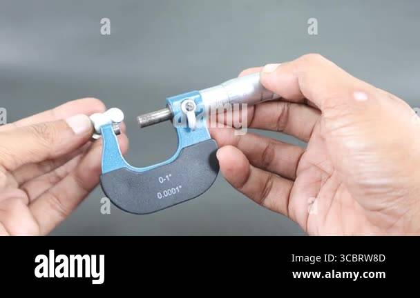 Hand measure diameter hex bolt using screw micrometer on black ...