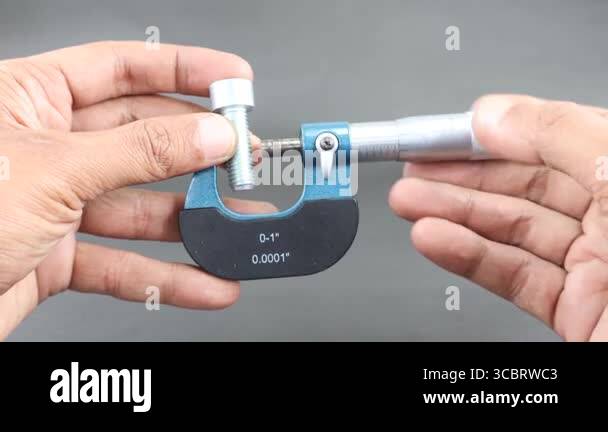 Hand measure diameter hex bolt using screw micrometer on black ...