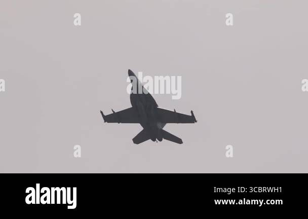 F/A-18F Super Hornet performs aerobatic maneuvers in overcast skies ...