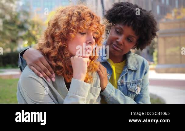 Two women engage in a supportive moment where one friend offers comfort ...