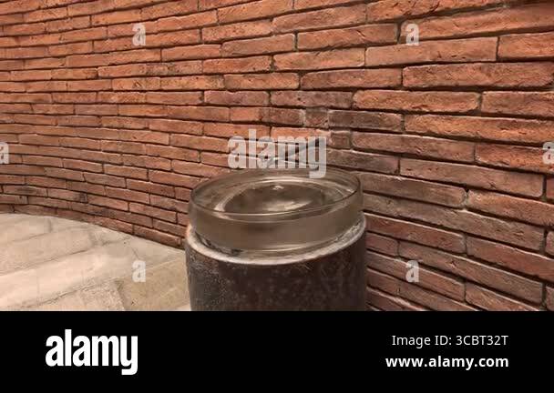 Glass jar overflows with water against brick wall Stock Video Footage ...