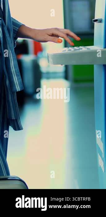Close-up, woman, with luggage, checks in at automated check-in counter ...