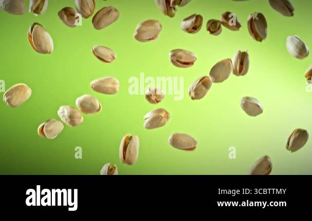 Super Slow Motion Shot of Falling Pistachio Nuts on Green Gradient ...