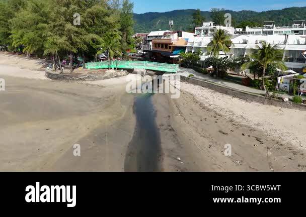 Aerial view of a bridge over a sandy channel during low tide at Kamala ...