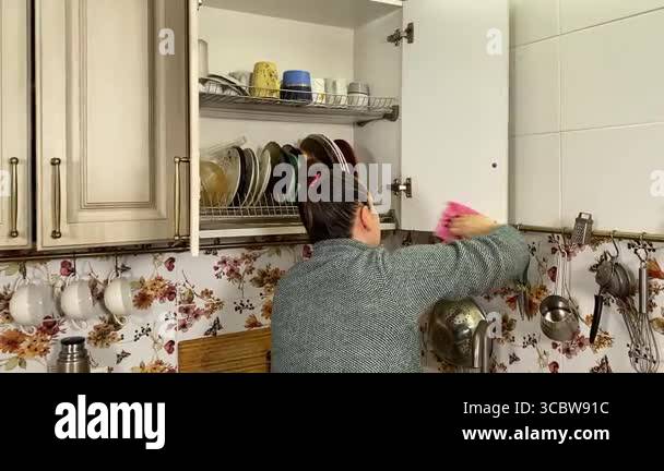 Young woman doing household chores at home, staying productive and ...