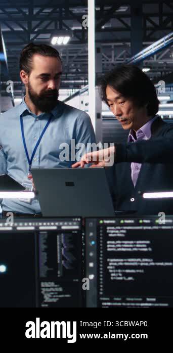 Vertical video Happy data center colleagues collaborating on neural network software development ...