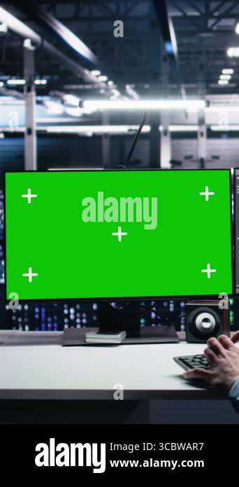 Vertical video Server room technician using AI on green screen PC to review diagnostics. IT ...