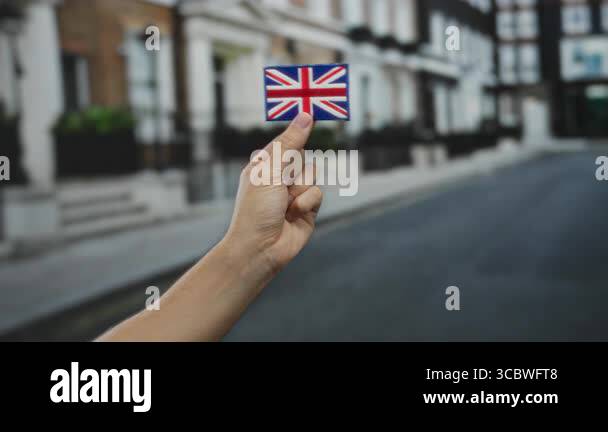 Man holding union jack embroidery in hand on a city street in great ...