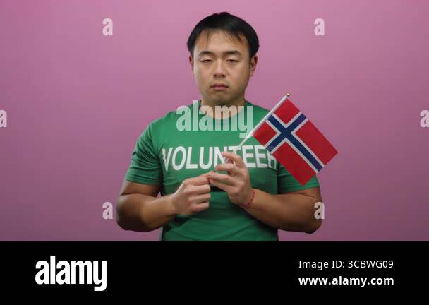 Young asian man holds norwegian flag while gesturing listening against ...