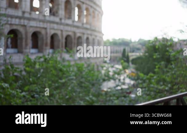 Blurred view of the colosseum in rome with greenery and bokeh effect ...