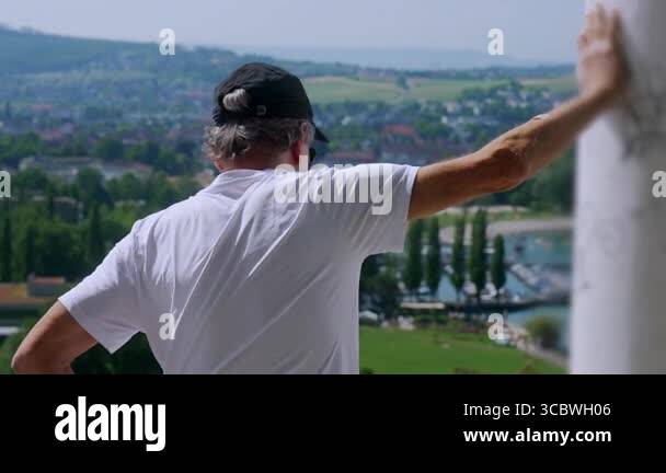 Older man standing side view with one arm extended against column ...