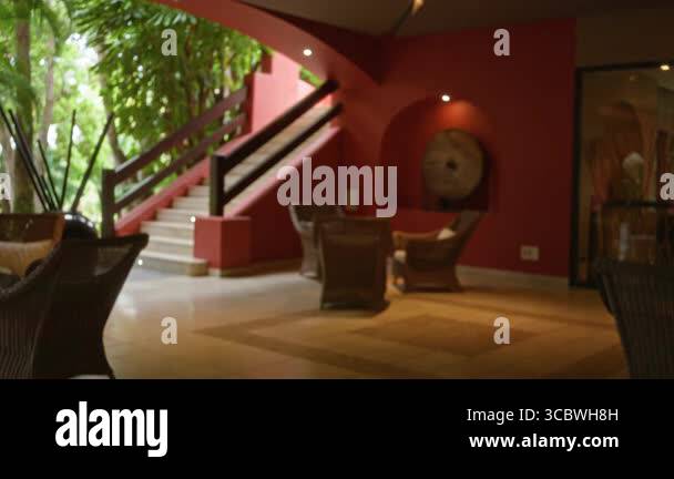 Luxury hotel lobby with red walls features elegant wicker chairs and ...
