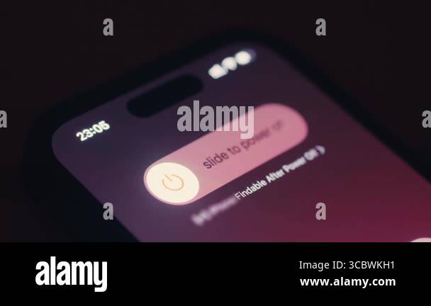 Powering down smartphone at night, displaying slide to power off button ...