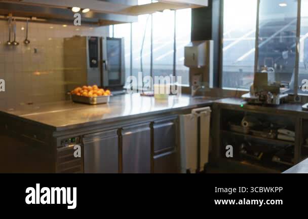 Blurry kitchen scene with stainless steel counters, oranges, and ...
