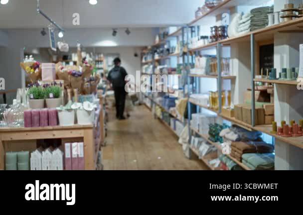 Blurred shop interior with defocused man and woman shopping among decor ...
