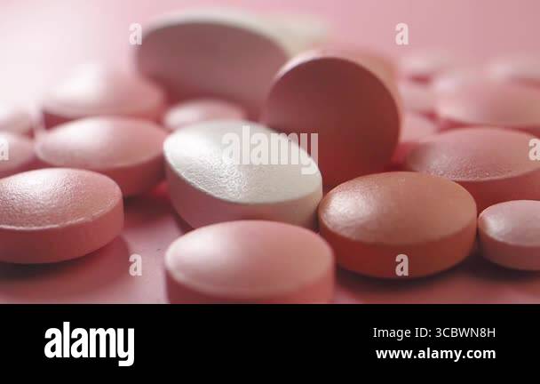 Colorful tablets lay on a soft pink background, displaying their shapes ...